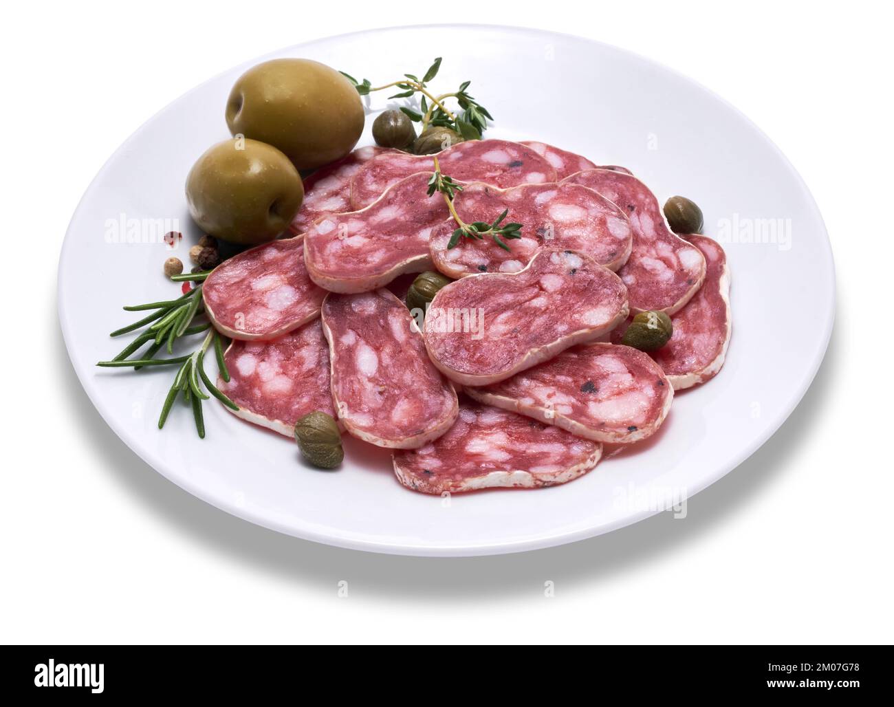 slices of Spanish Fuet thin dried salami sausage on white ceramic plate ...