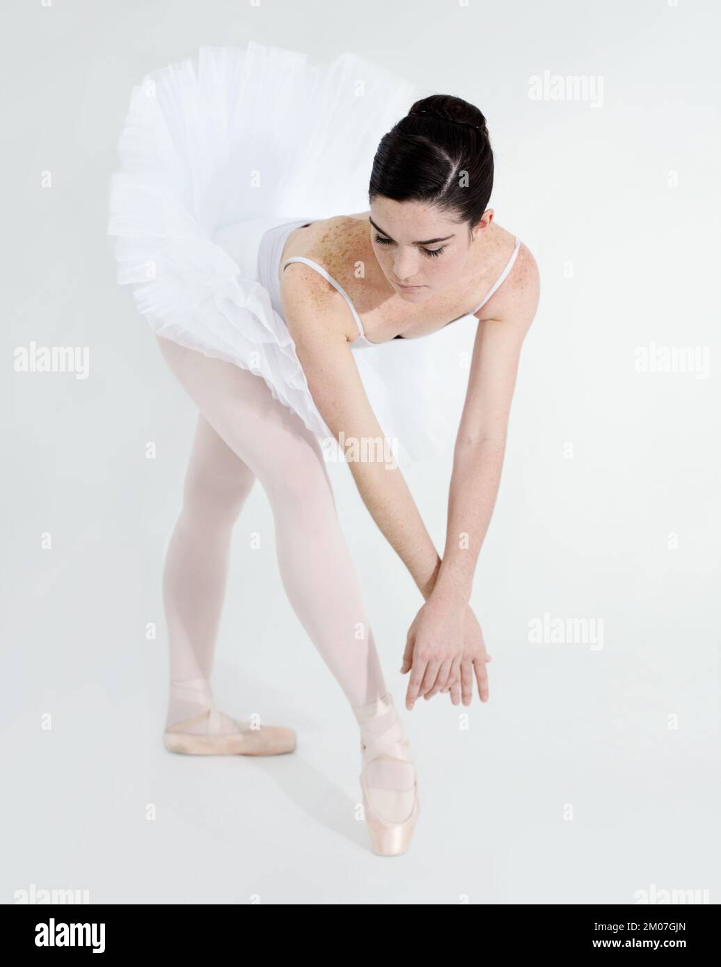 Delicate and graceful. Supple young ballerina dancing against a white ...