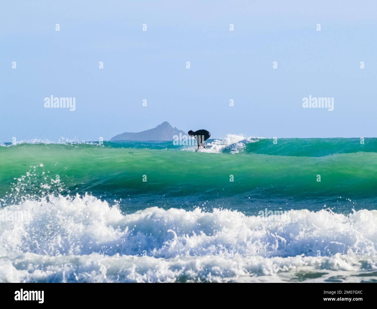 Ship leaving port of Tauranga at sunrise with Mayor Island on horizon ...