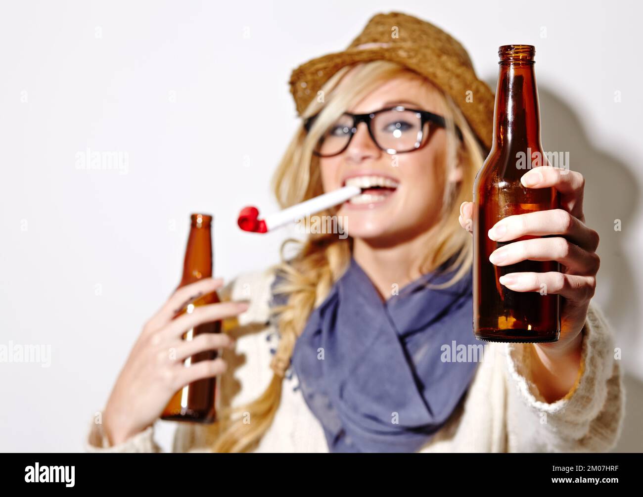 Its party time. A beautiful young woman holding two beers in her hands ...