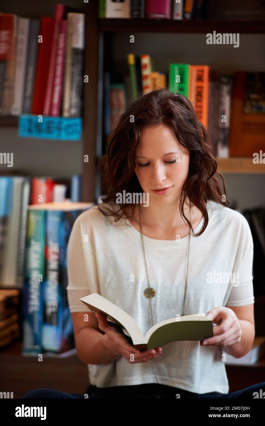 Everything she wants to know is in her hands. A young woman reading a ...