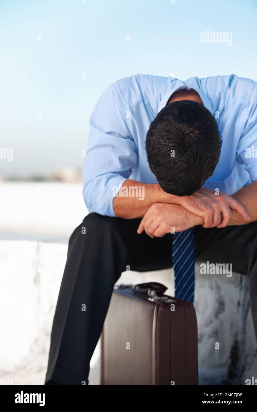 Feeling the effects of a stressful job. An upset business man with hsi ...