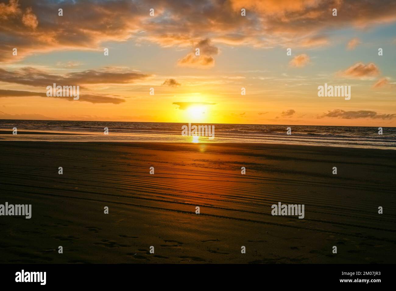 Dramatic dark sky over Beach in silhouette as sunsets on distant ...