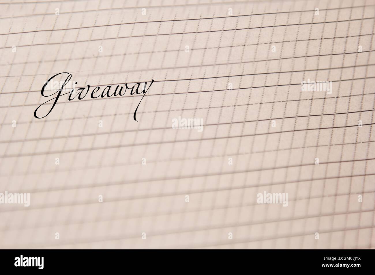 word giveaway is written with an ink pen on a white paper sheet with ...