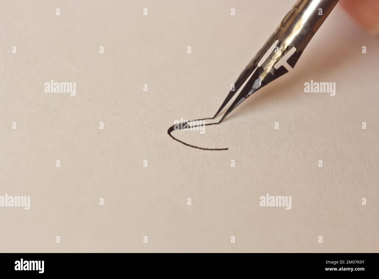 hand writes with the inky pen on a white paper sheet with stripes ...