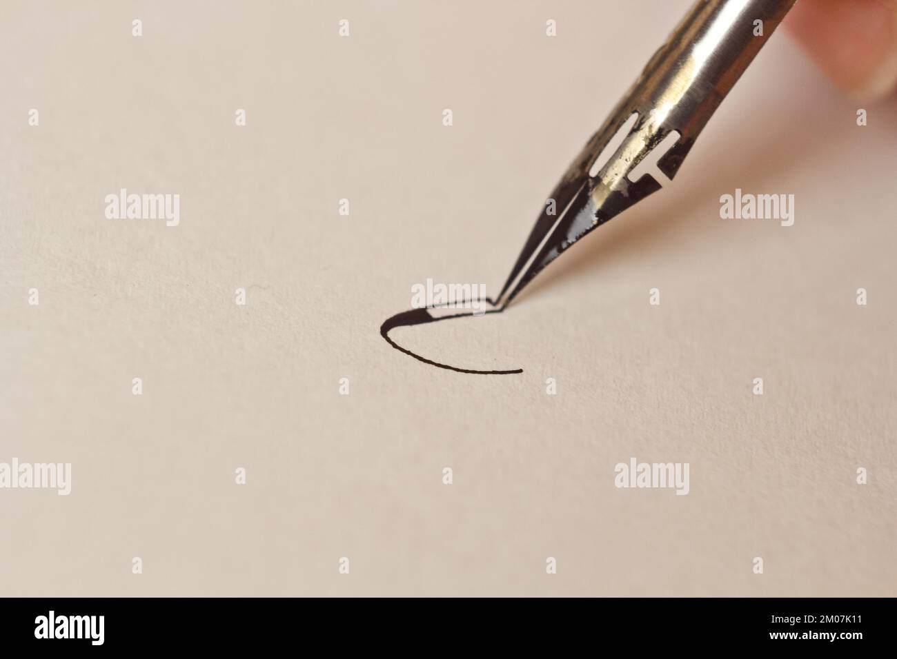 hand writes with the inky pen on a white paper sheet with stripes ...