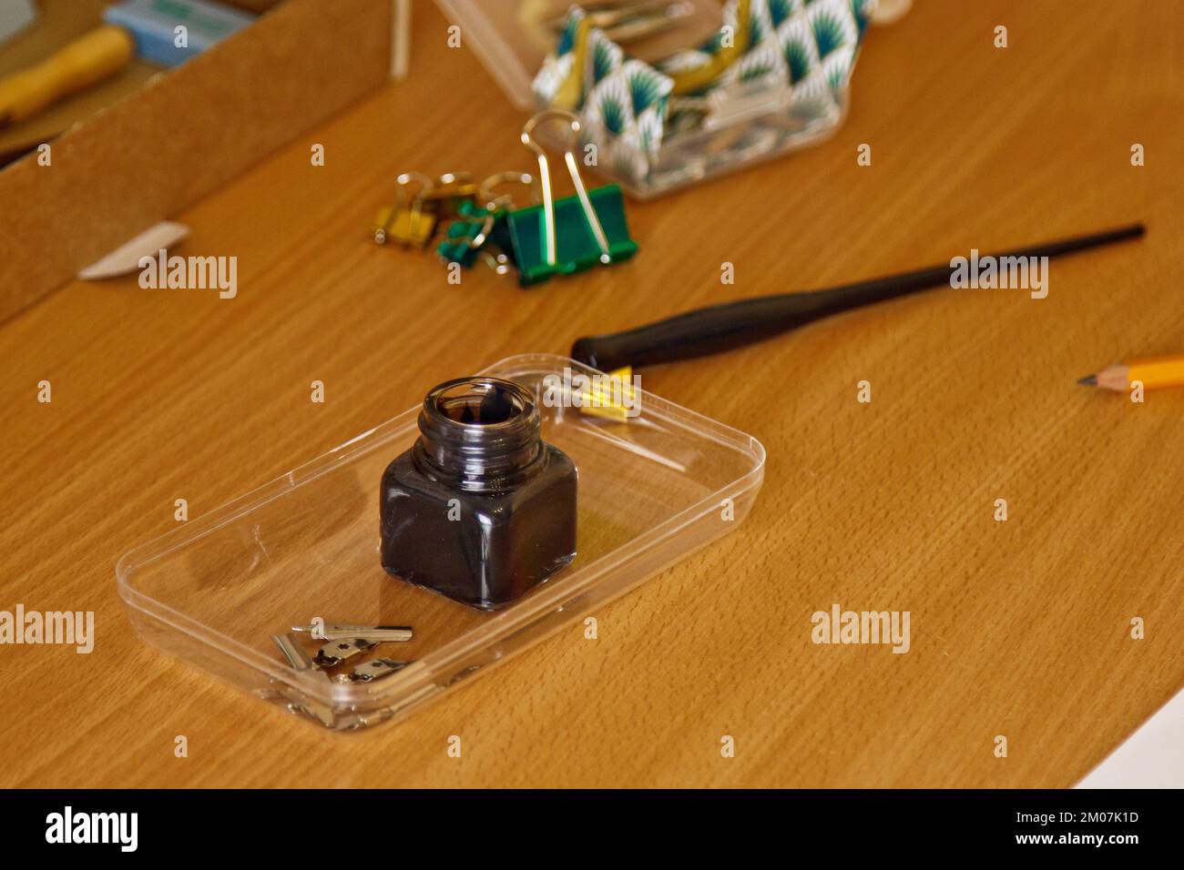 Inkwell and stationery on a wooden desk close-up. empty paper sheet for ...