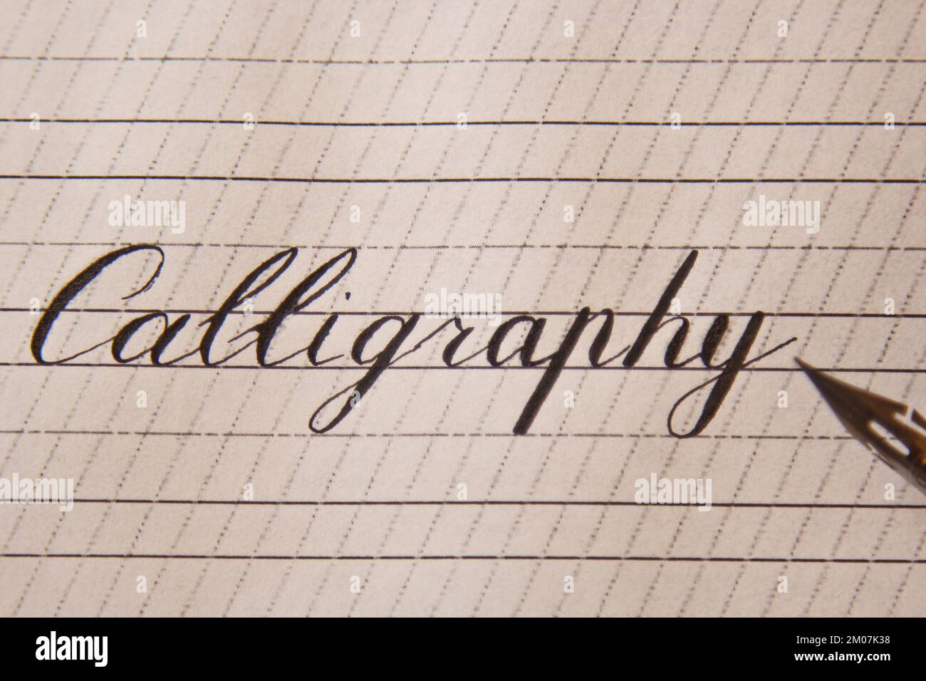 word calligraphy is written with an ink pen on a white paper sheet with ...