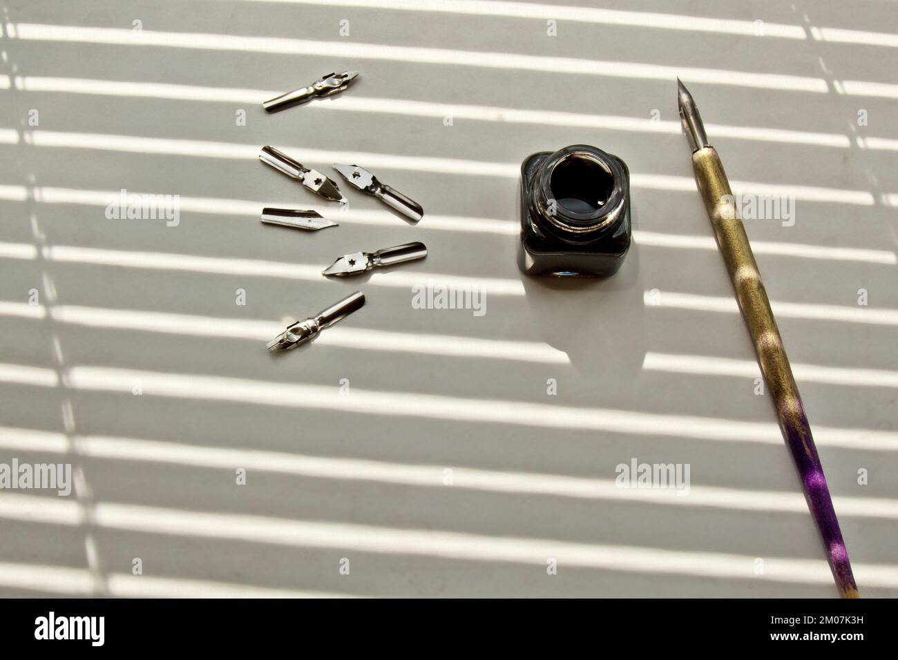 Inkpot with metal tips for the ink pen on a white background in solar ...