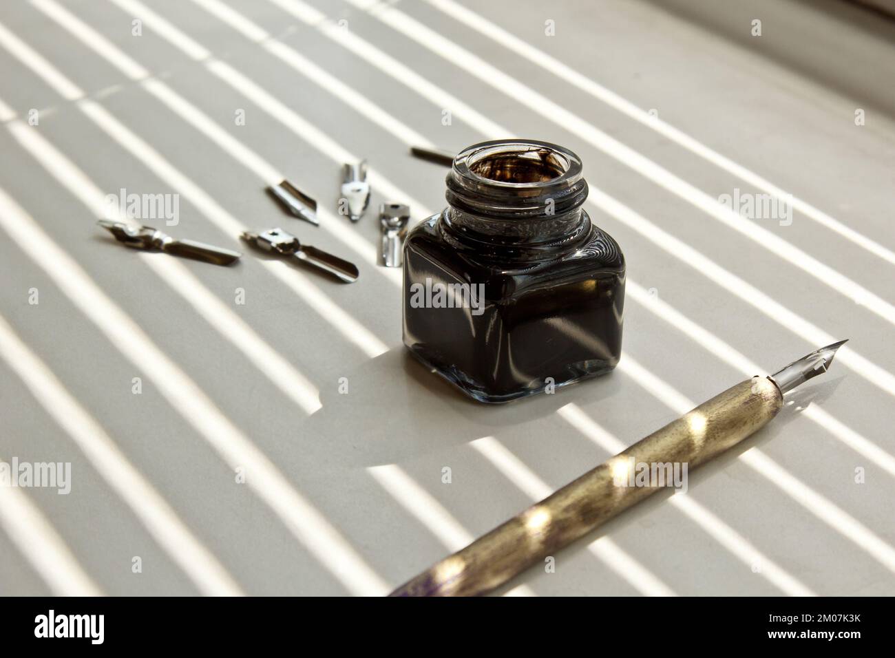 Inkpot with metal tips for the ink pen on a white background in solar ...
