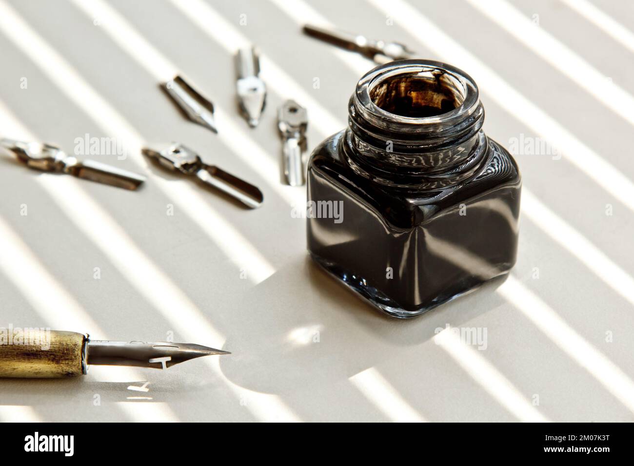 Inkpot with metal tips for the ink pen on a white background in solar ...