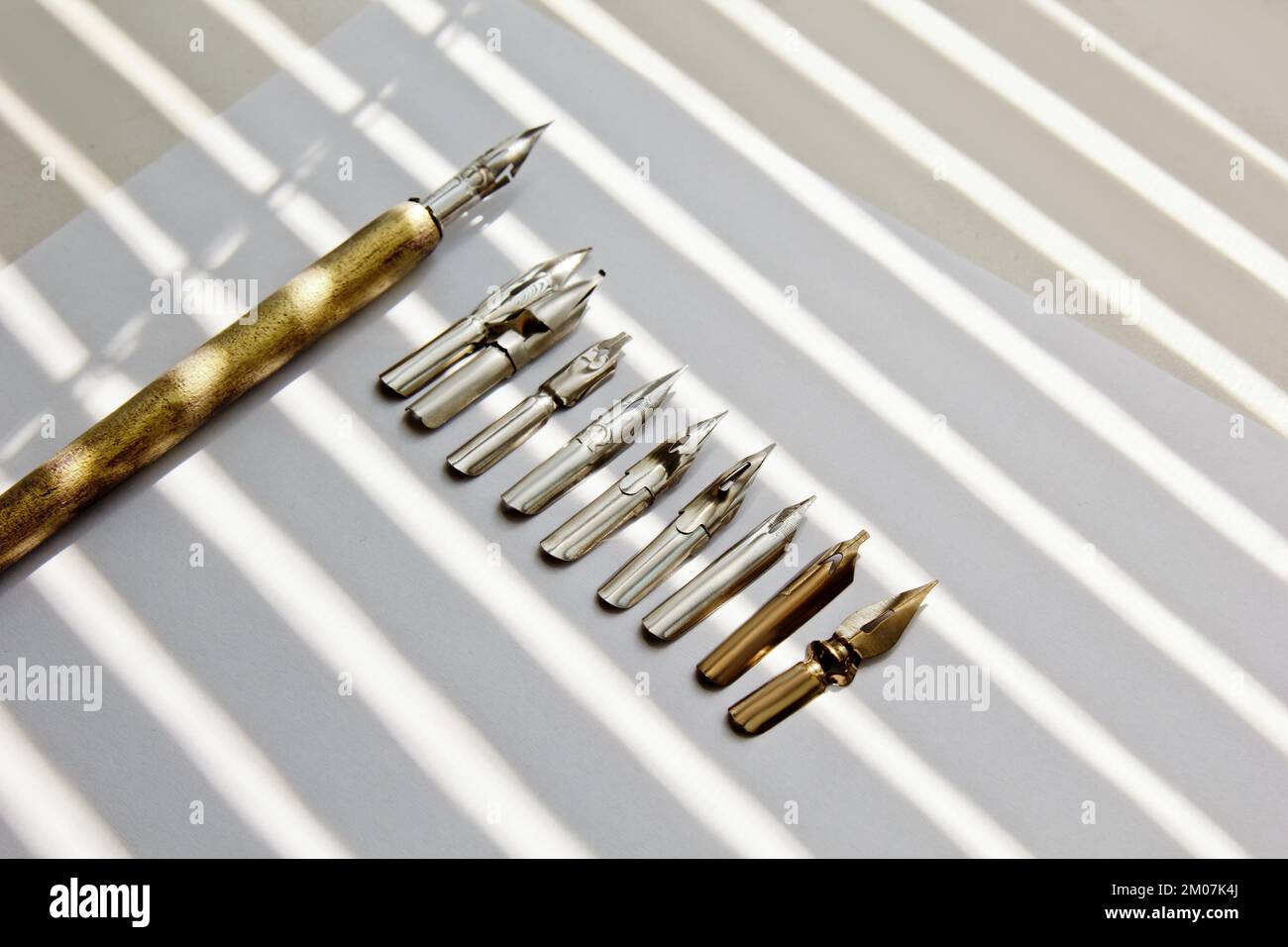 metal tips for the ink pen on a white background in solar rays ...