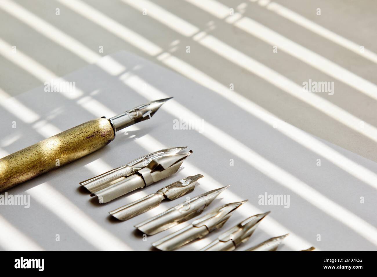 metal tips for the ink pen on a white background in solar rays ...