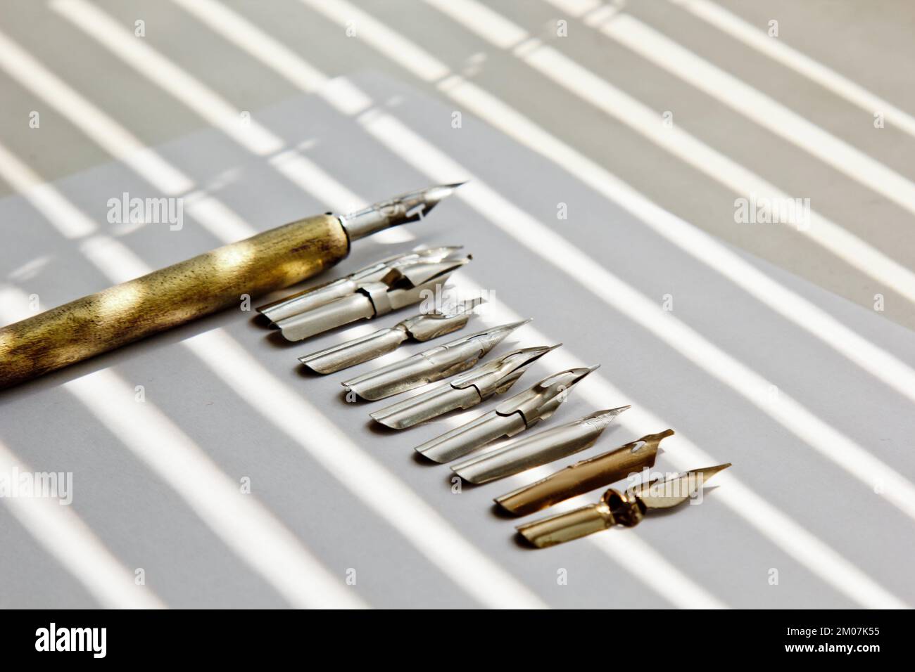 metal tips for the ink pen on a white background in solar rays ...