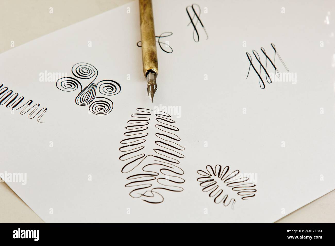 patterns drawn with an ink pen on a white paper sheet with stripes ...