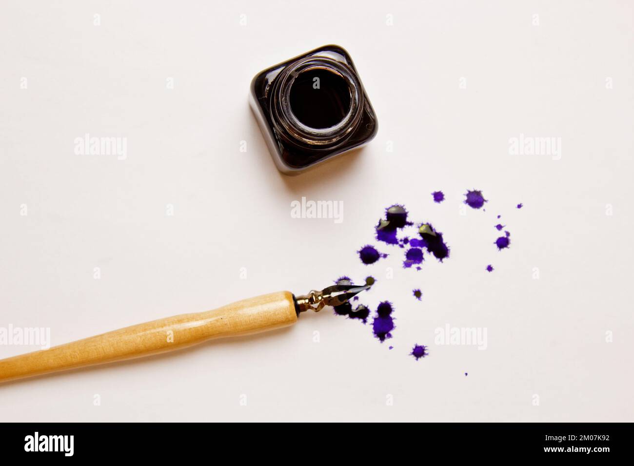 ink stain drawn with an ink pen on a white paper sheet with inkwell ...