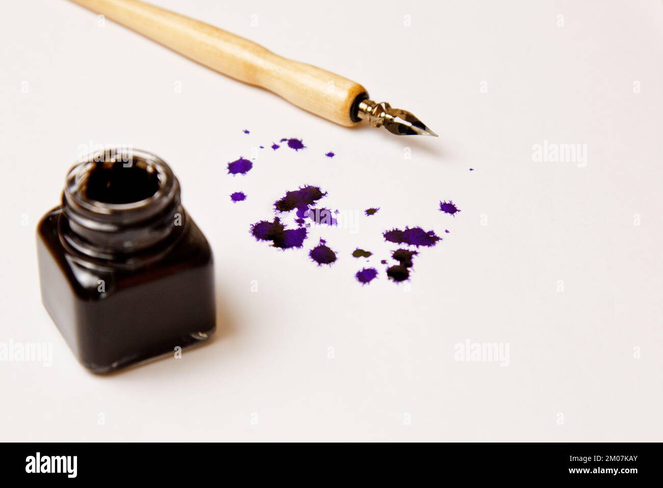 ink stain drawn with an ink pen on a white paper sheet with inkwell ...