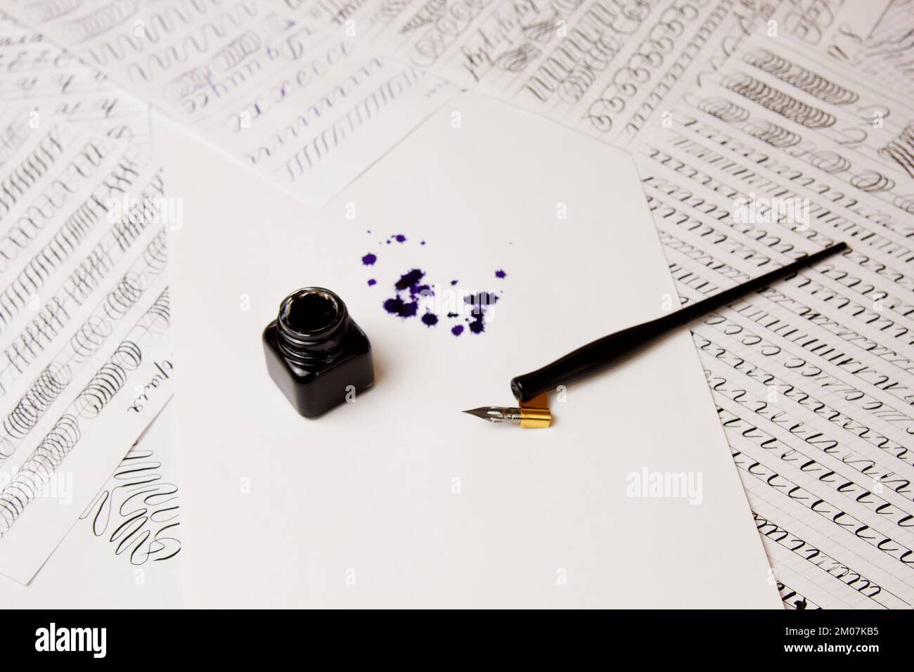 ink stain drawn with an ink pen on a white paper sheet with inkwell ...