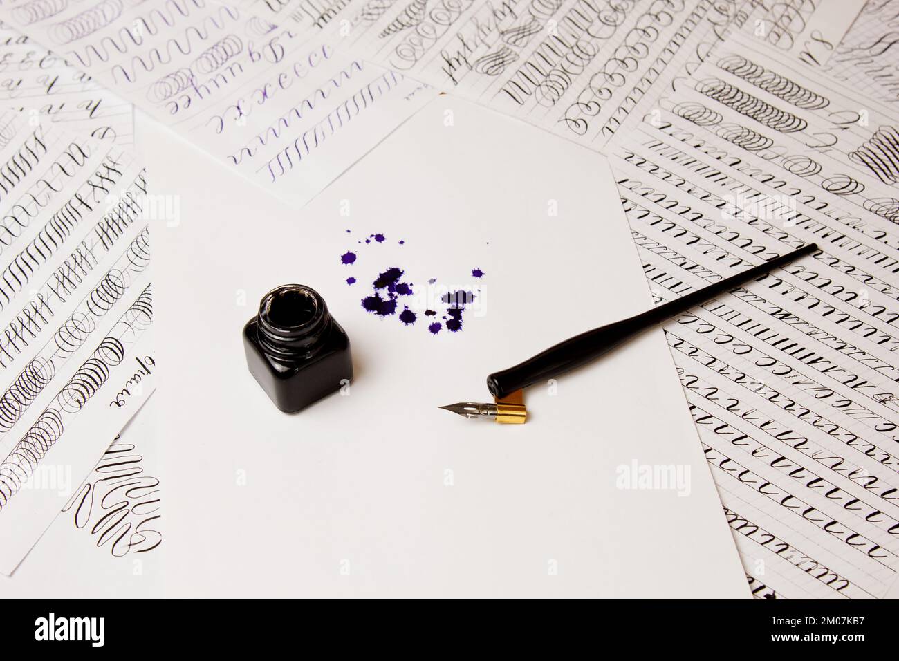 ink stain drawn with an ink pen on a white paper sheet with inkwell ...