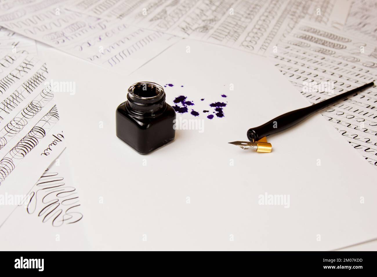 ink stain drawn with an ink pen on a white paper sheet with inkwell ...