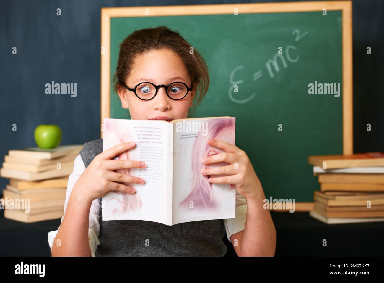 Captivated by the storyline. A cute brunette girl looking fascinated by ...