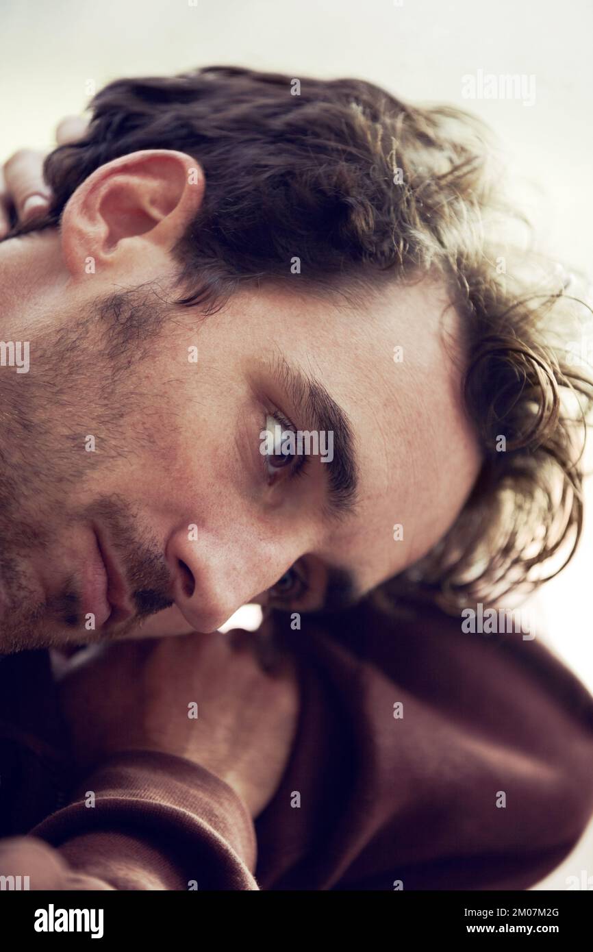 Worrying about the future. A young man resting his head on his arms and ...