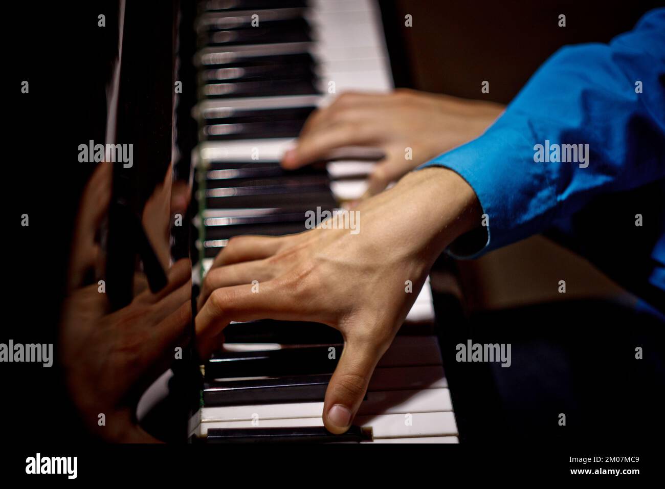 two male hands on the piano. palms lie on the keys crosswise and play ...