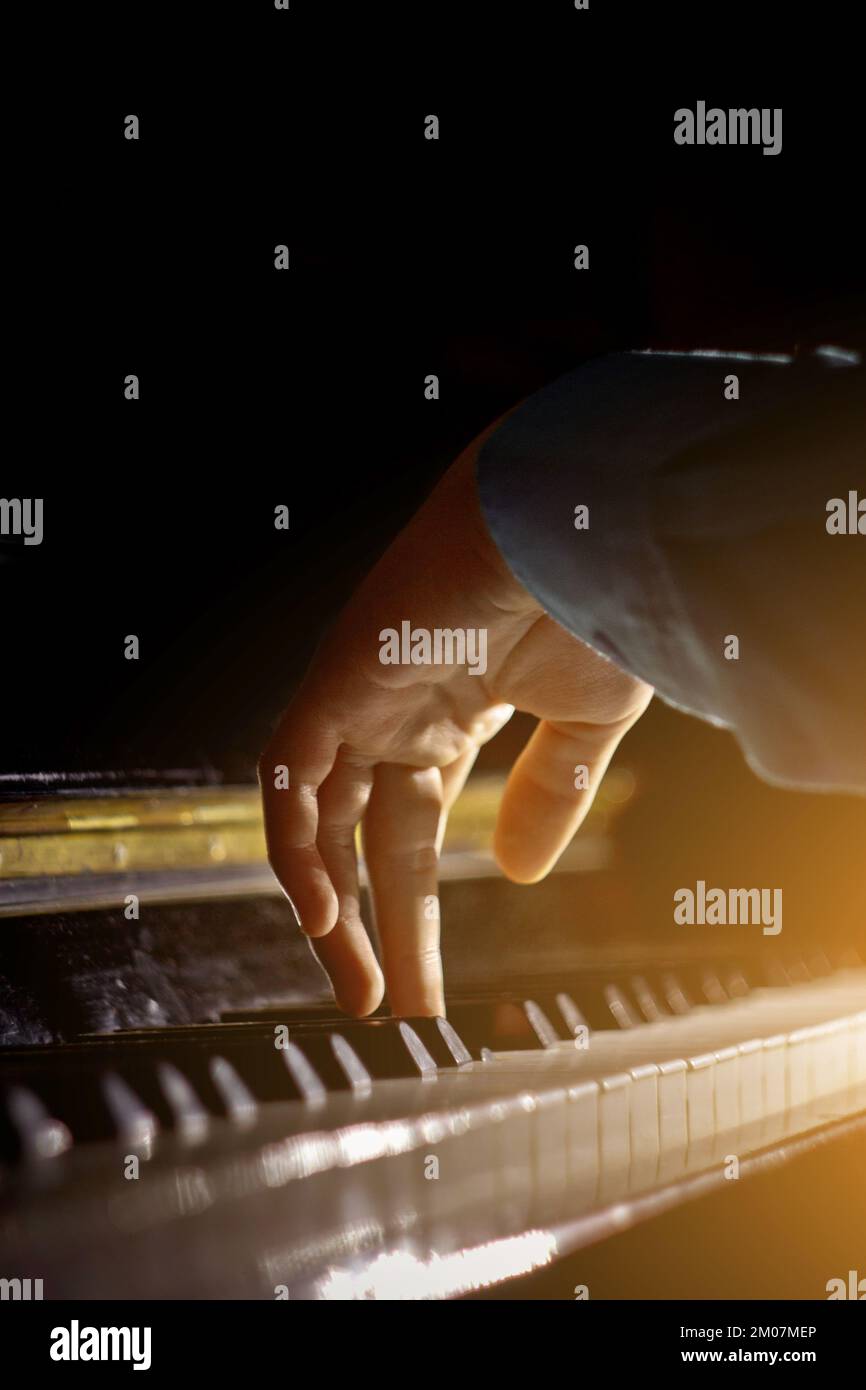 one male hand on the piano. The palm lies on the keys and plays the ...