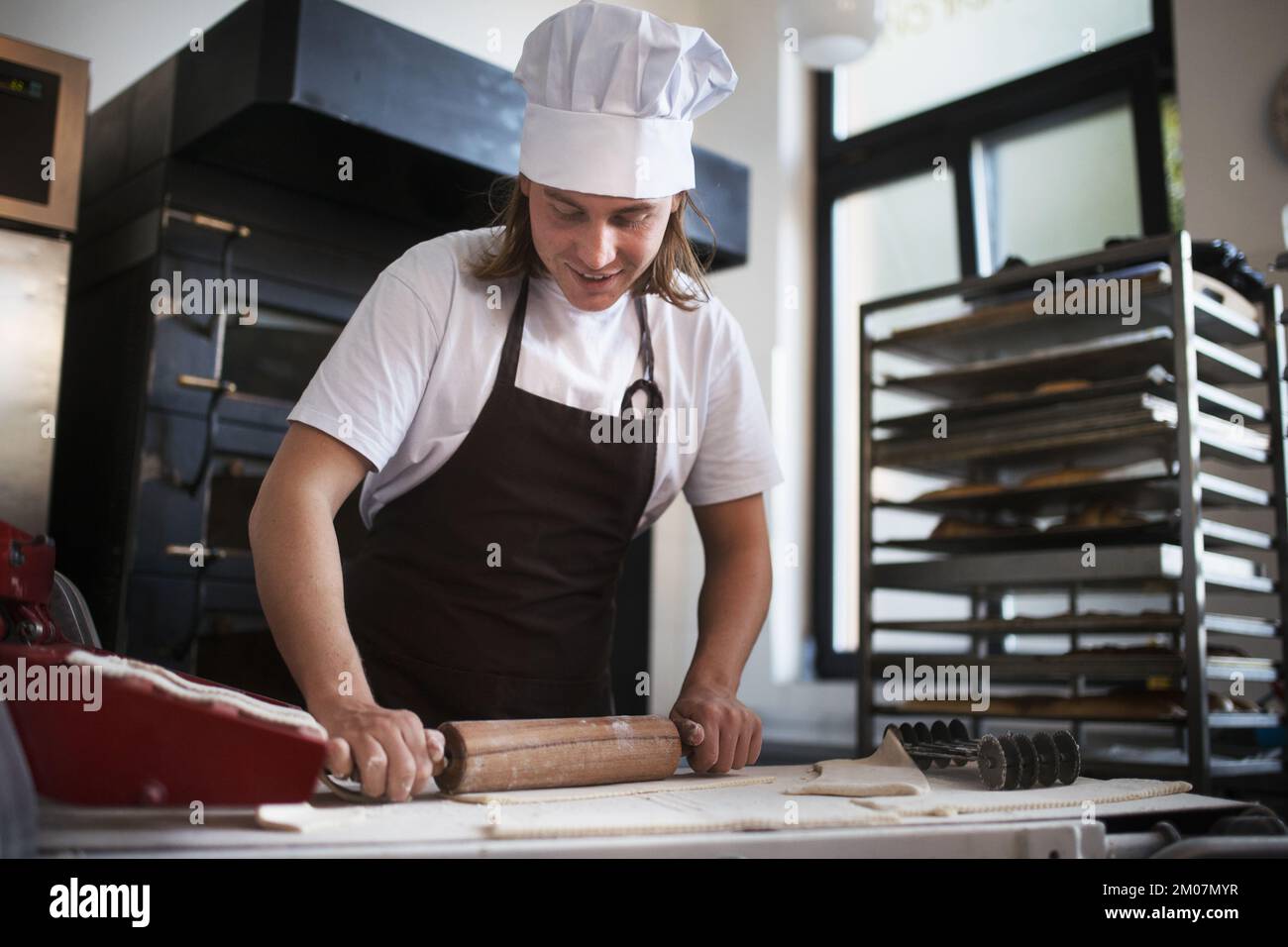 Young baker preparing pastries in bakery Stock Photo - Alamy