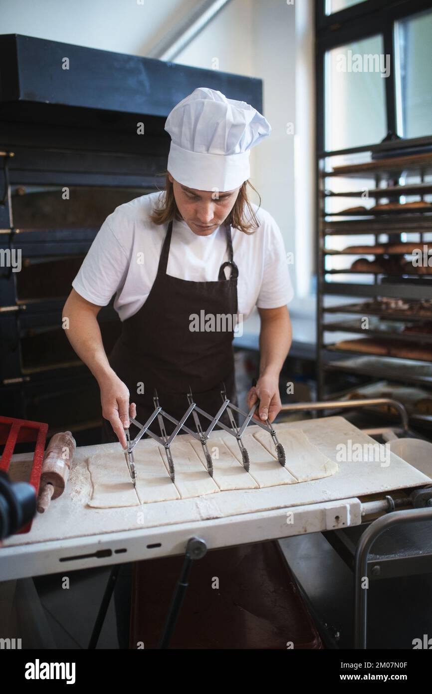 Young baker preparing pastries in bakery Stock Photo - Alamy