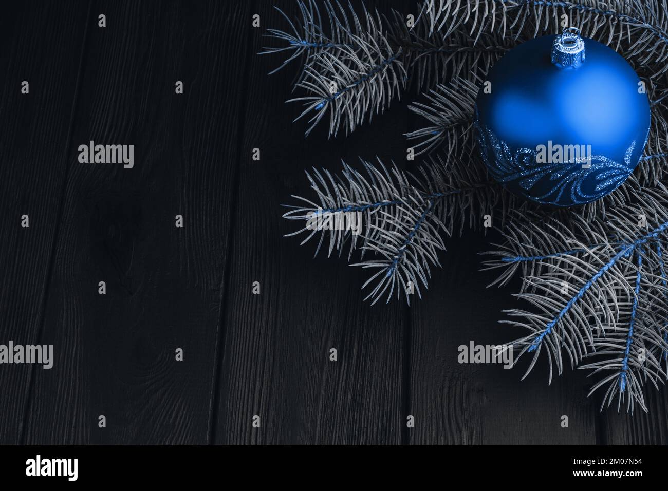 Top view of fur-tree branches and balls frame on wooden background with ...