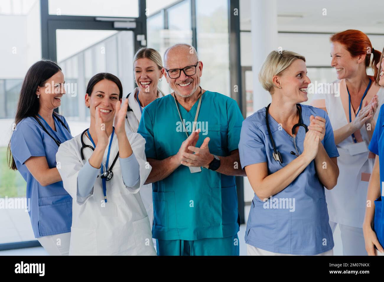 Portrait of happy doctors, nurses and other medical staff clapping, in ...