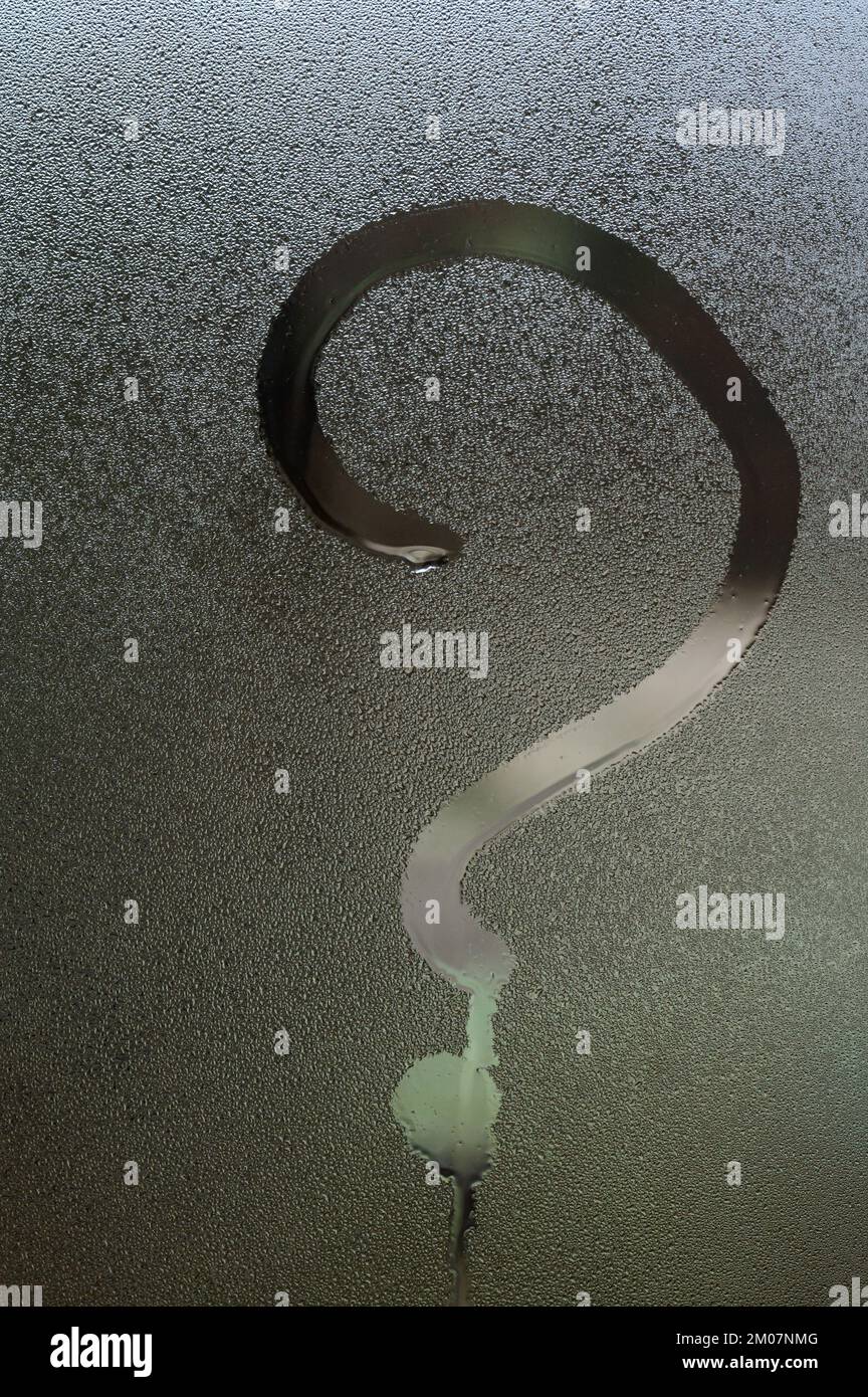 A question mark is drawn on glass with condensation, the effect of ...