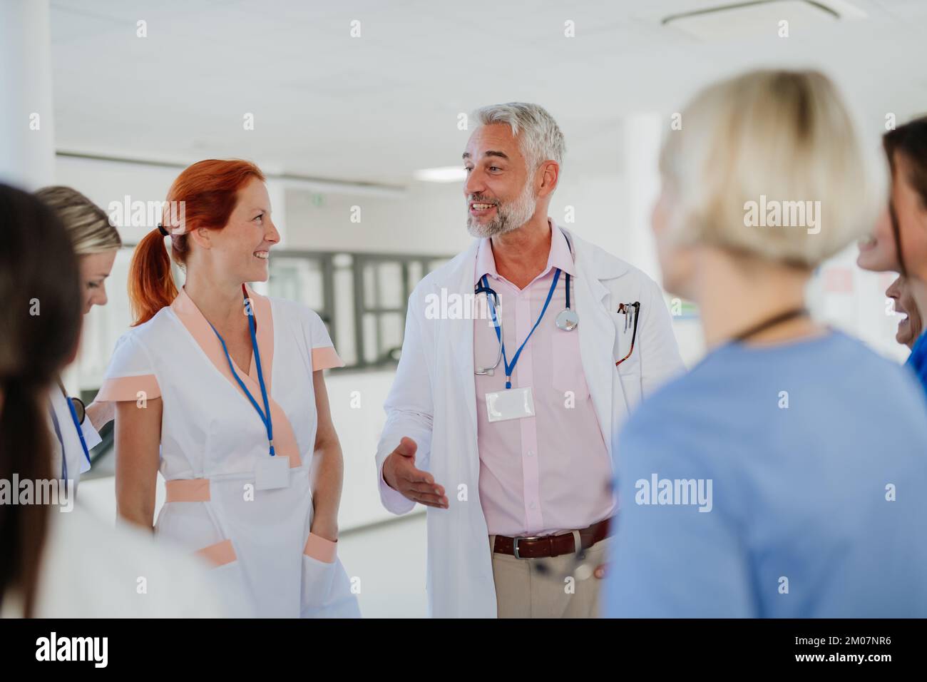Team of doctors discussing something at a hospital corridor Stock Photo ...