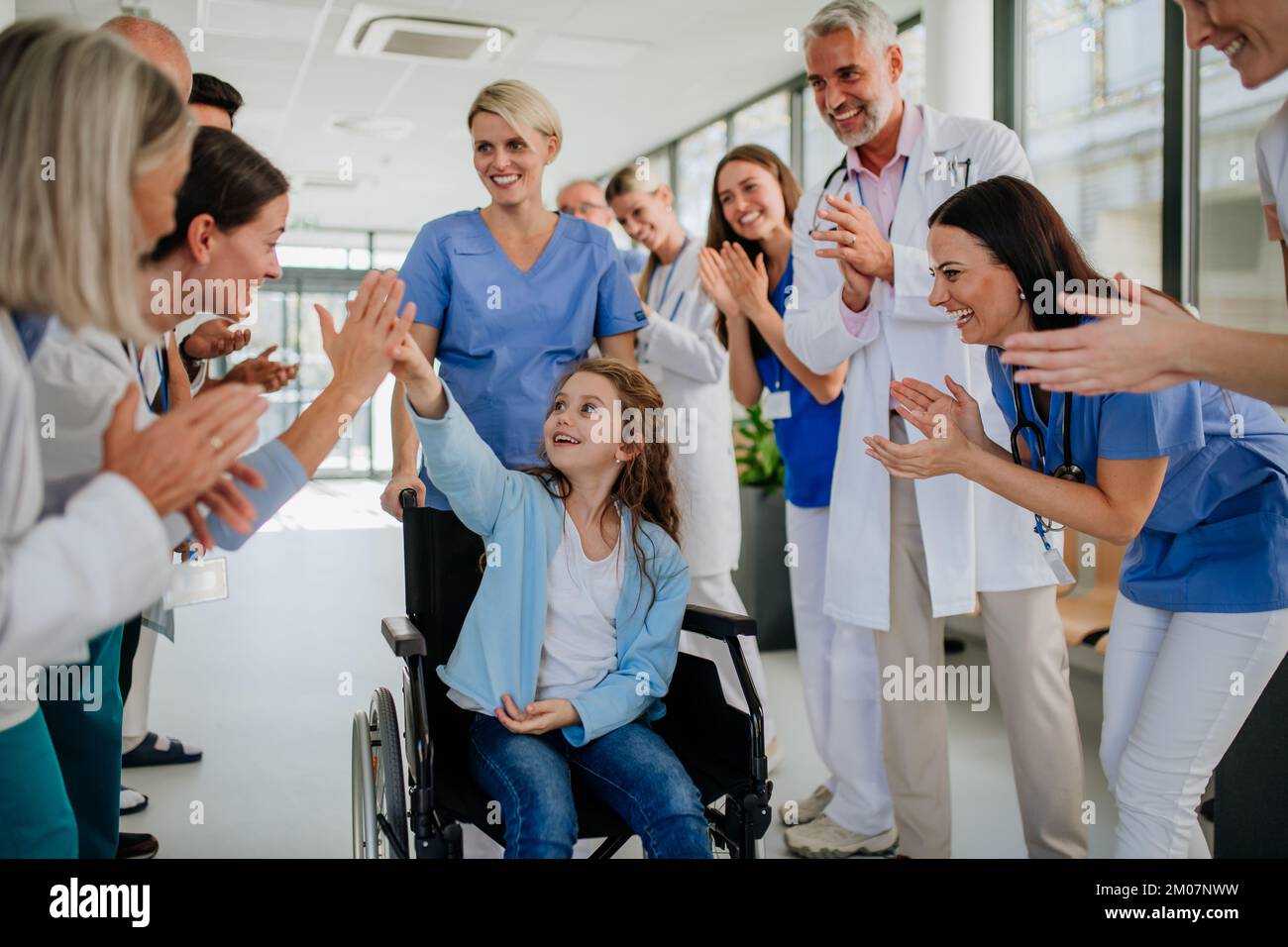 Medical staff clapping to little girl patient who recovered from ...