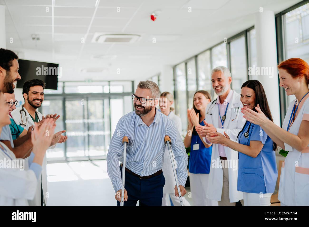 Medical staff clapping to patient who recovered from serious accident ...