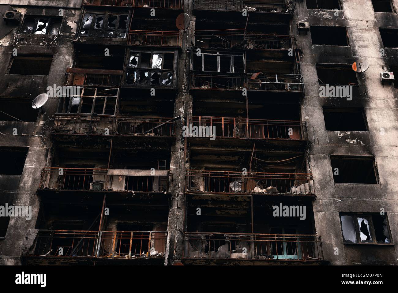 A burnt-out high-rise in the war zone. Damage to a residential building ...