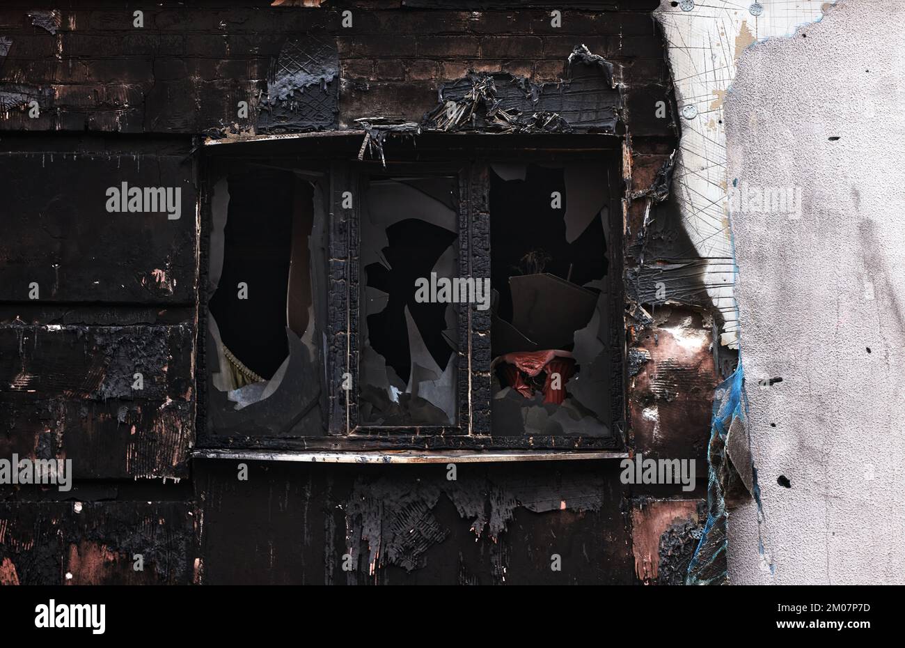 A burnt-out high-rise in the war zone. Damage to a residential building ...