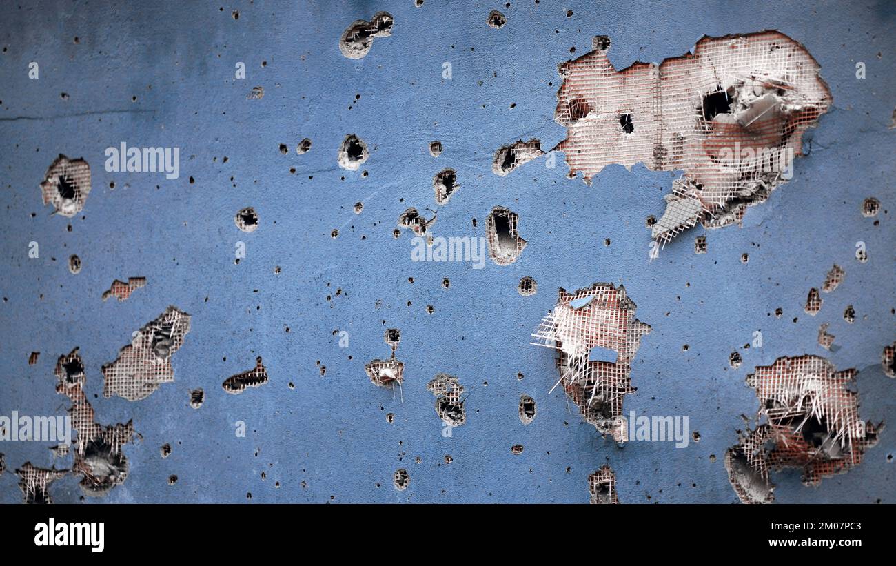 Holes from artillery shell fragments in the wall of an apartment ...
