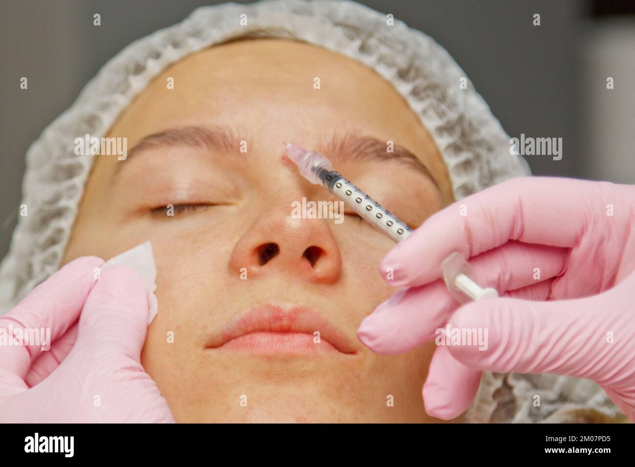 contour plastic. A cosmetologist injects a botulinum toxin to tighten ...