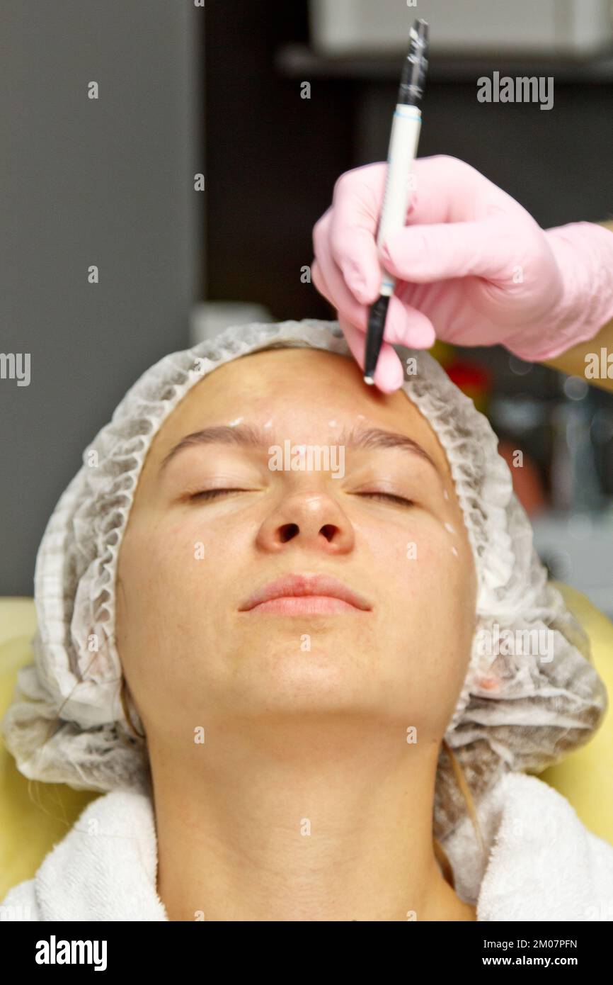 Attractive girl patient with instructions on her face for plastic ...