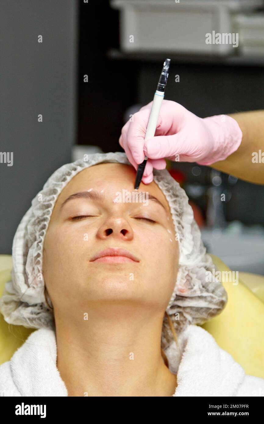 Attractive girl patient with instructions on her face for plastic ...