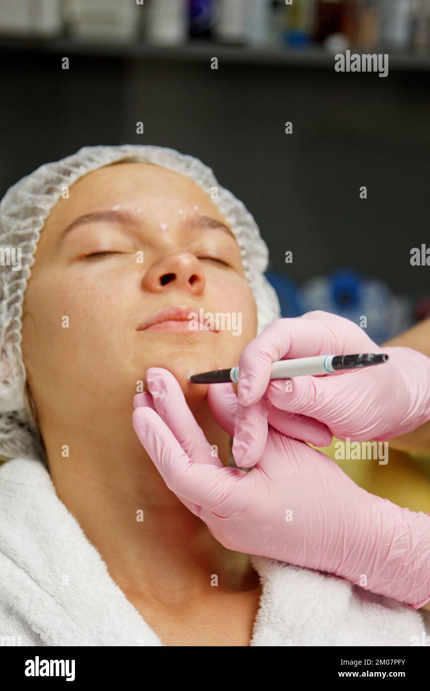 Attractive girl patient with instructions on her face for plastic ...