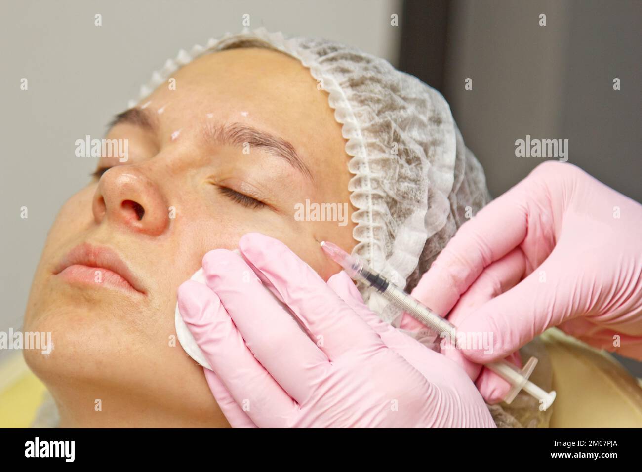 contour plastic. A cosmetologist injects a botulinum toxin to tighten ...