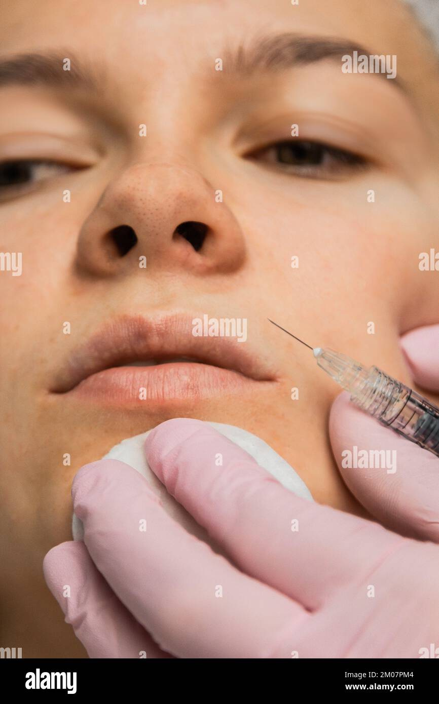 contour plastic. A cosmetologist injects a botulinum toxin to tighten ...