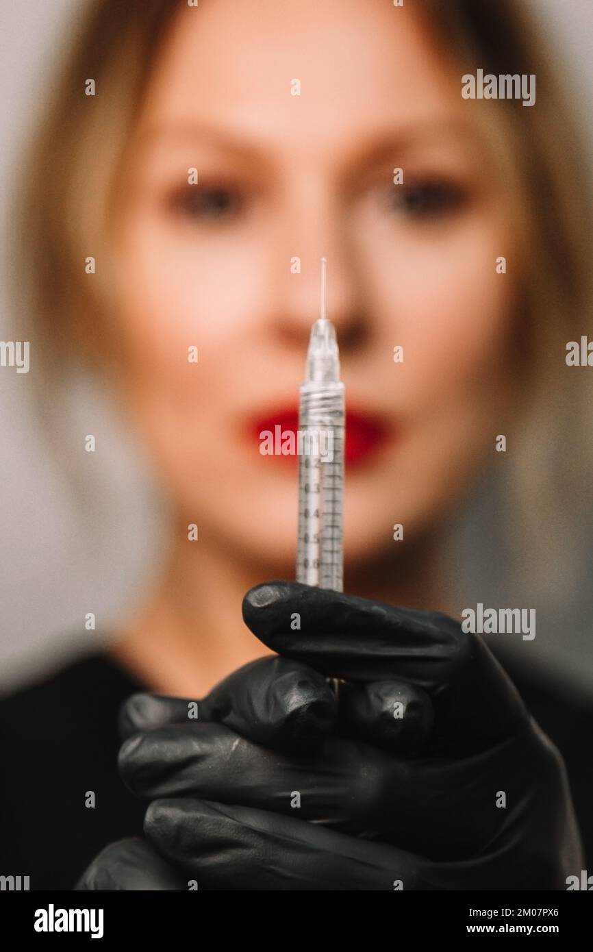 contour plastic. A cosmetologist injects a botulinum toxin to tighten ...