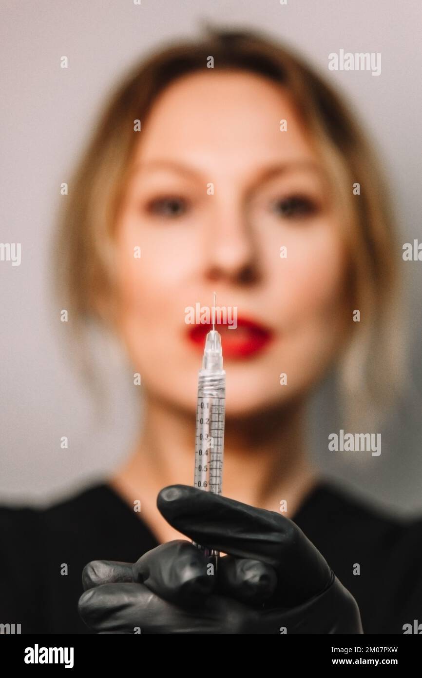 contour plastic. A cosmetologist injects a botulinum toxin to tighten ...