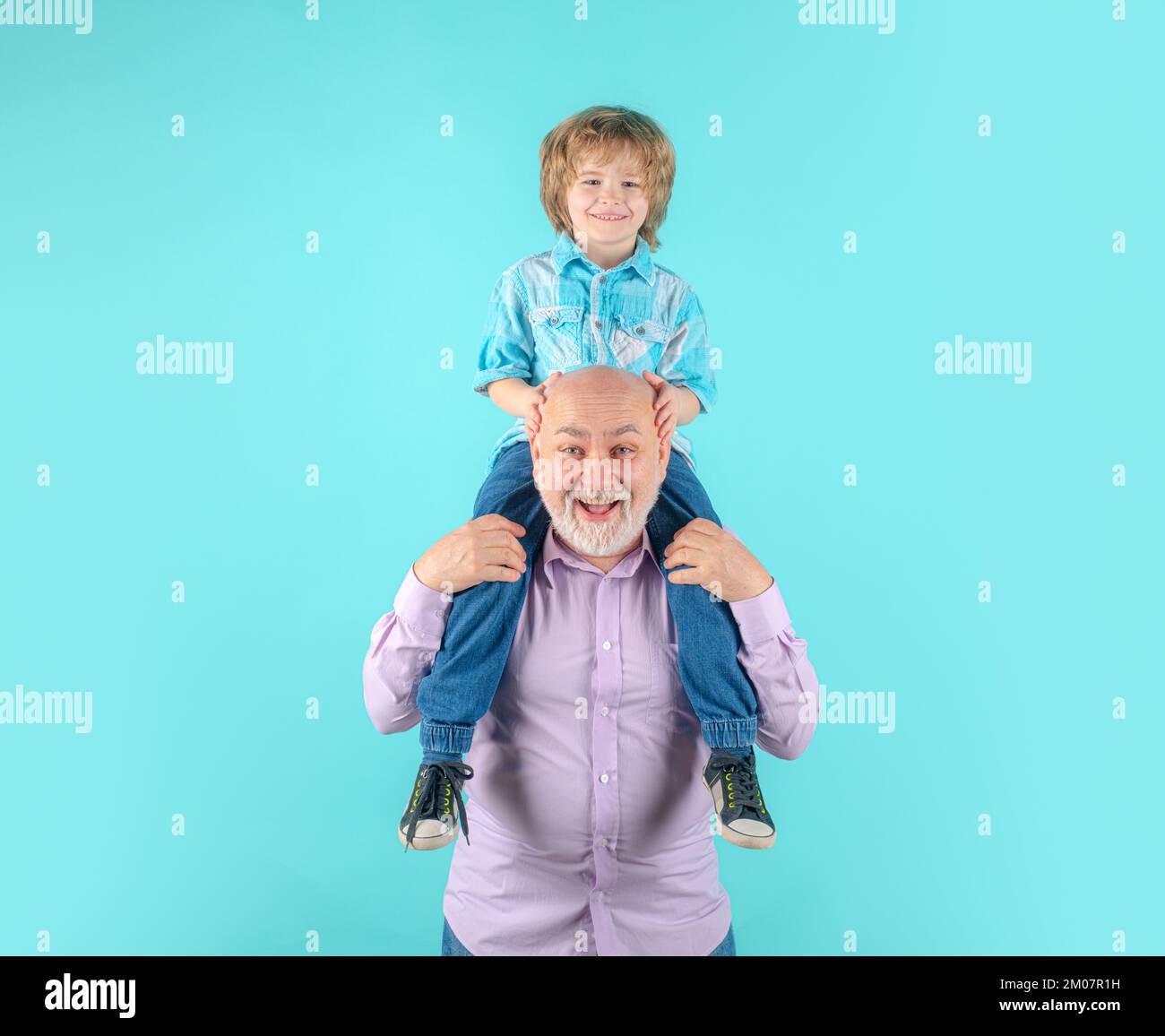 Young grandson and old grandfather piggyback with funny face isolated ...