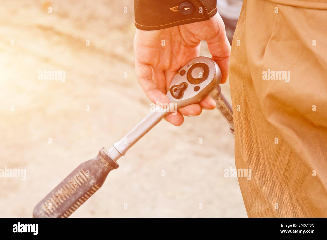 Auto mechanic man with electric screwdriver changing tire outside. Car ...