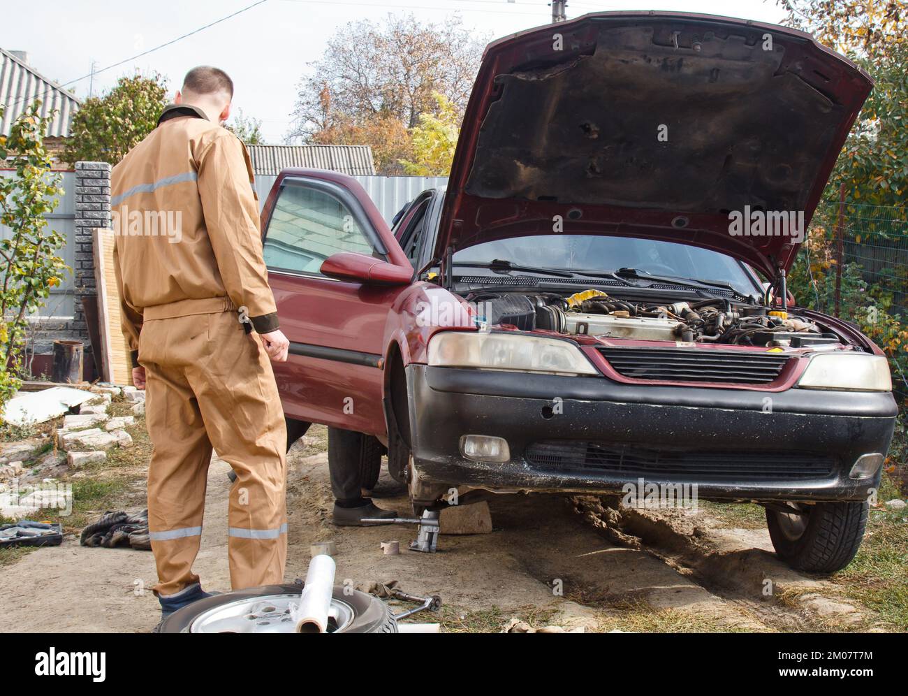 A mechanic removes a car tire. A man working on a machine to remove ...